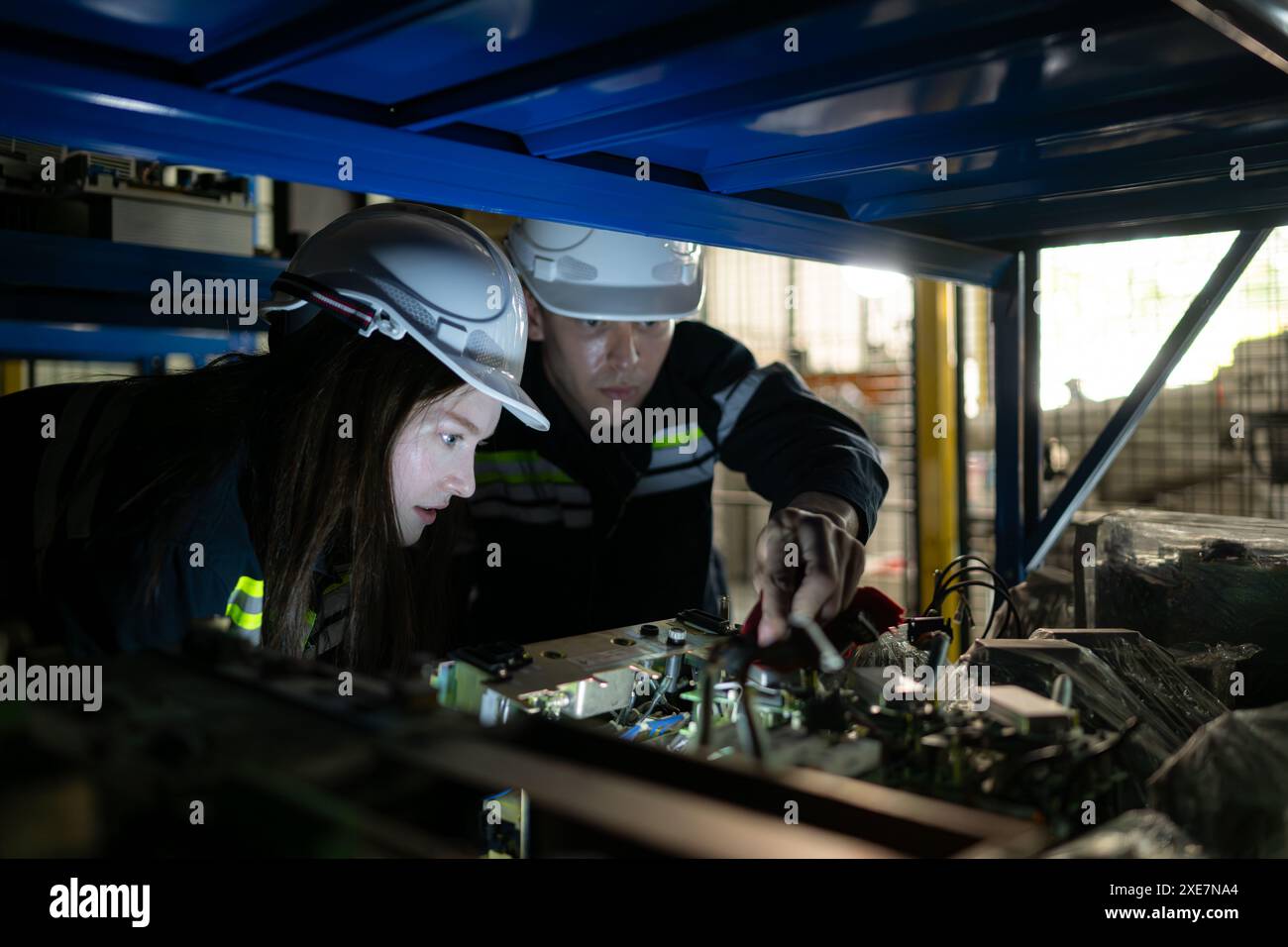 A young female engineer and a male supervisor work together in robotic ...