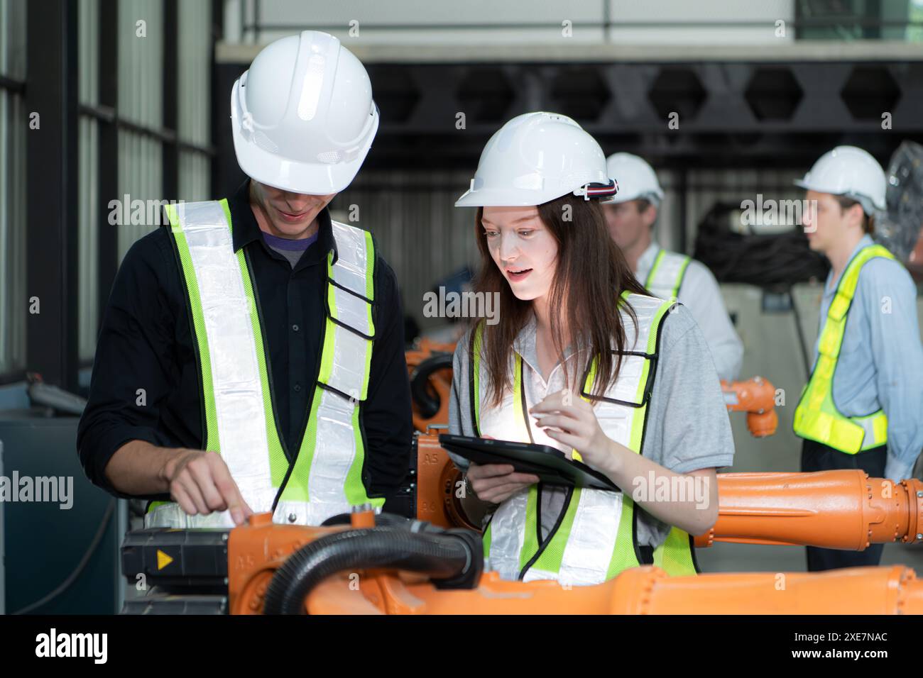 Group of engineers and technicians working together in a robotic arm ...