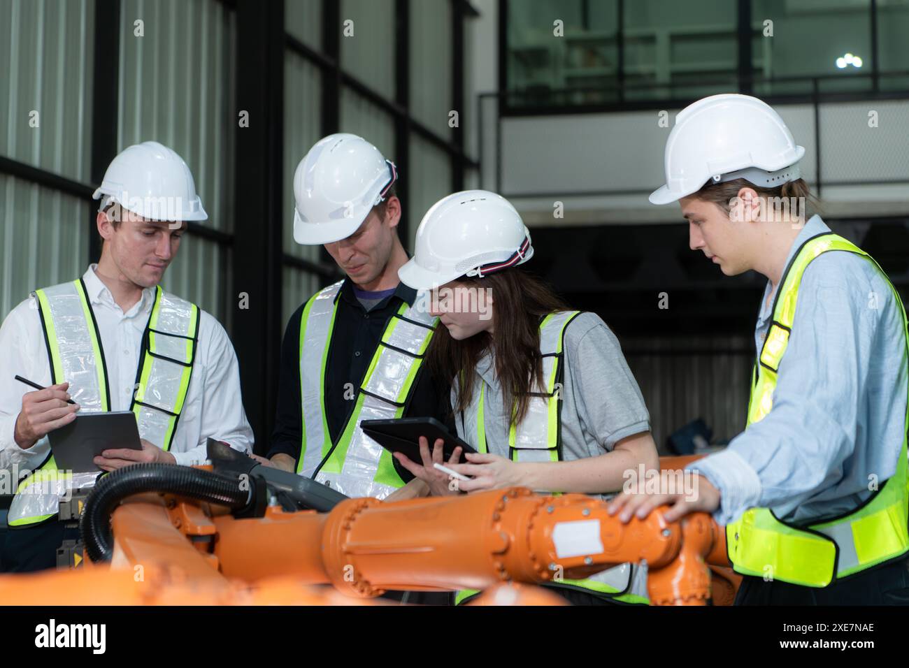 Group of engineers and technicians working together in a robotic arm ...