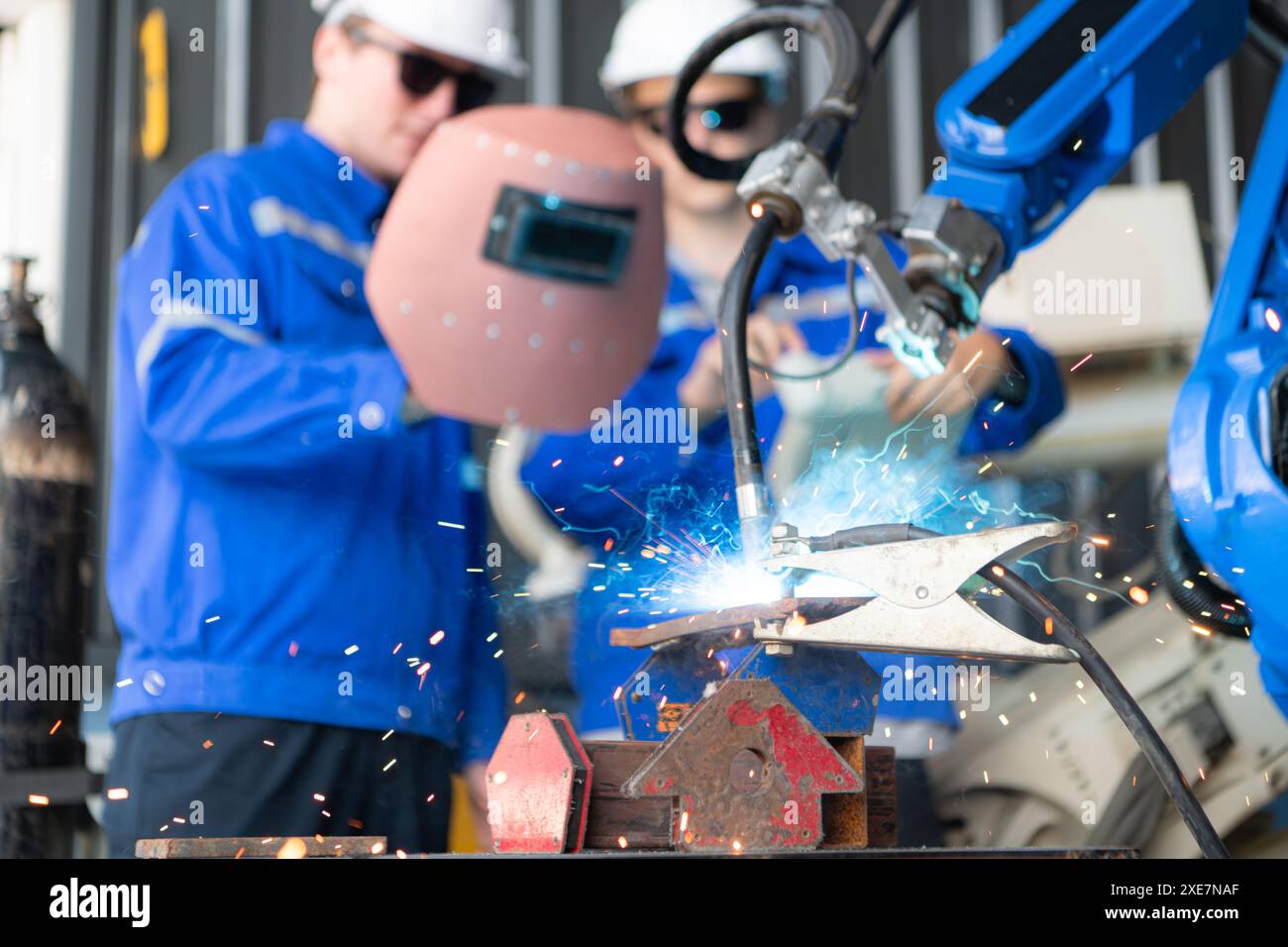 Industrial workers working with robotic arm welding machine in factory, Robotic arm welding ...