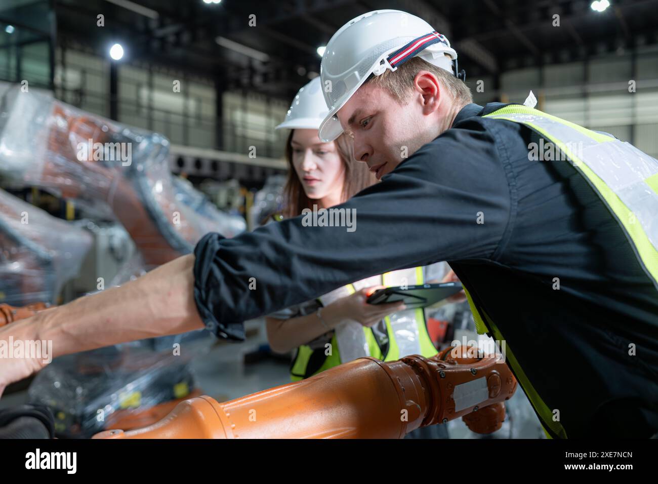 Both of engineers working together in a robotic arm factory, Robotic ...