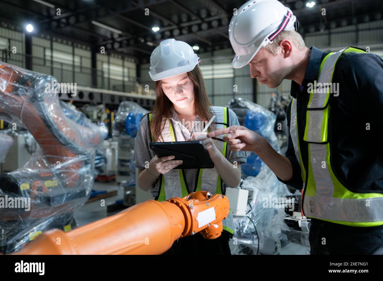 Both of engineers working together in a robotic arm factory, Robotic ...