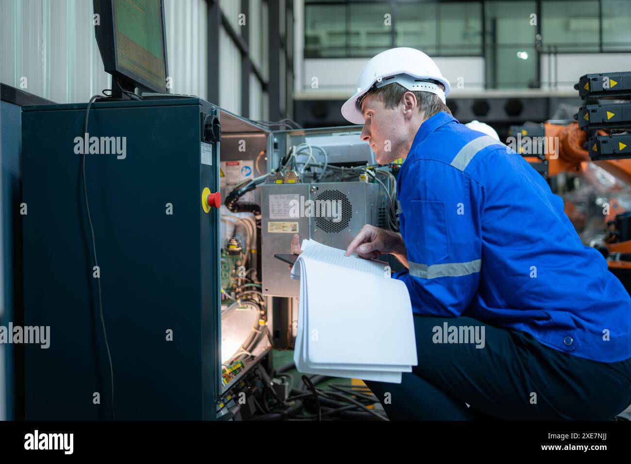 Technician working on the electrical control cabinet of robotic arm ...