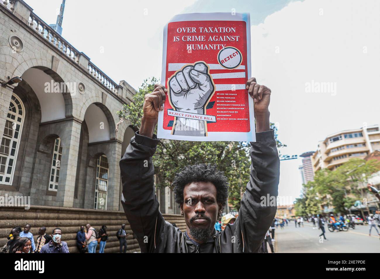 A protester holds a placard and shouts slogans, during the ...