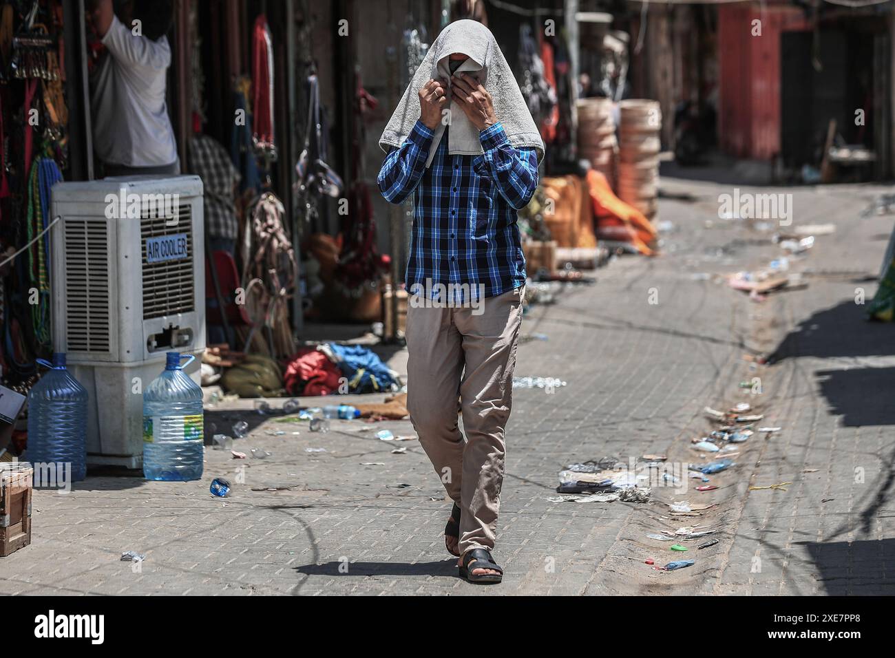 26 June 2024, Iraq, Baghdad: An Iraqi man shelters from the sun under a ...