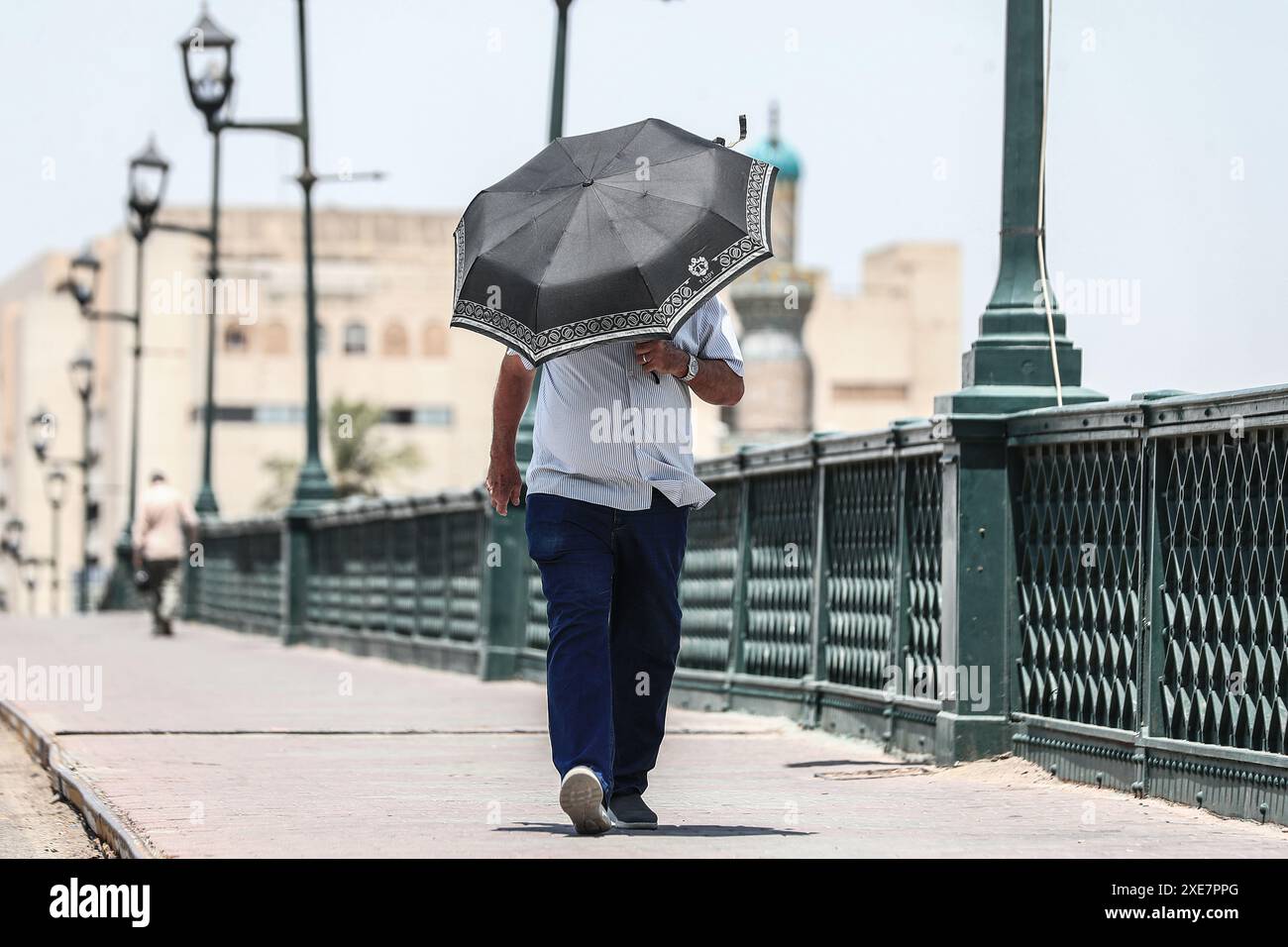 26 June 2024, Iraq, Baghdad: An Iraqi man shelters from the sun under ...
