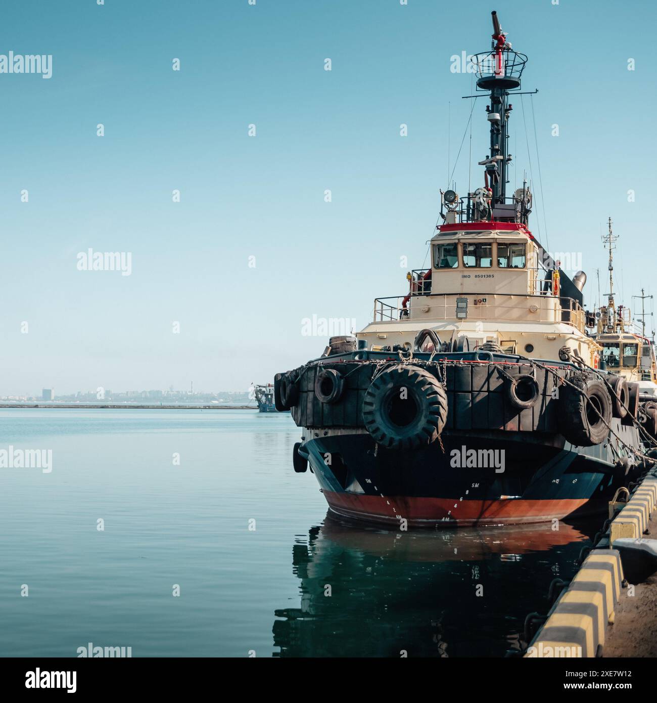 Beige tugboat moored to the wharf. Front view of old tugboat IMO ...