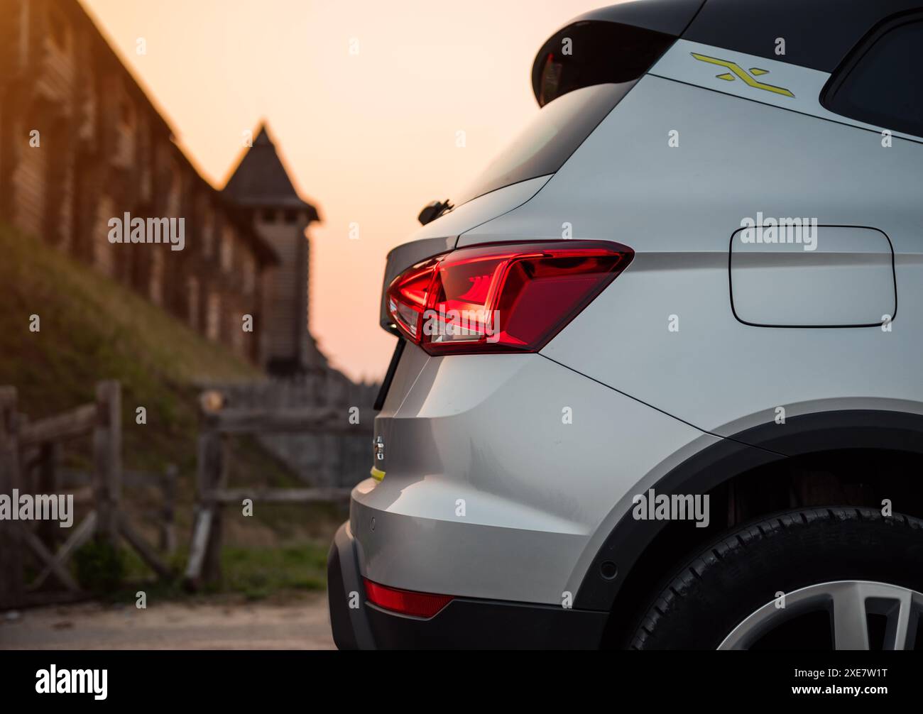 Side view of rear part of sporty compact crossover at sunset. Silver ...