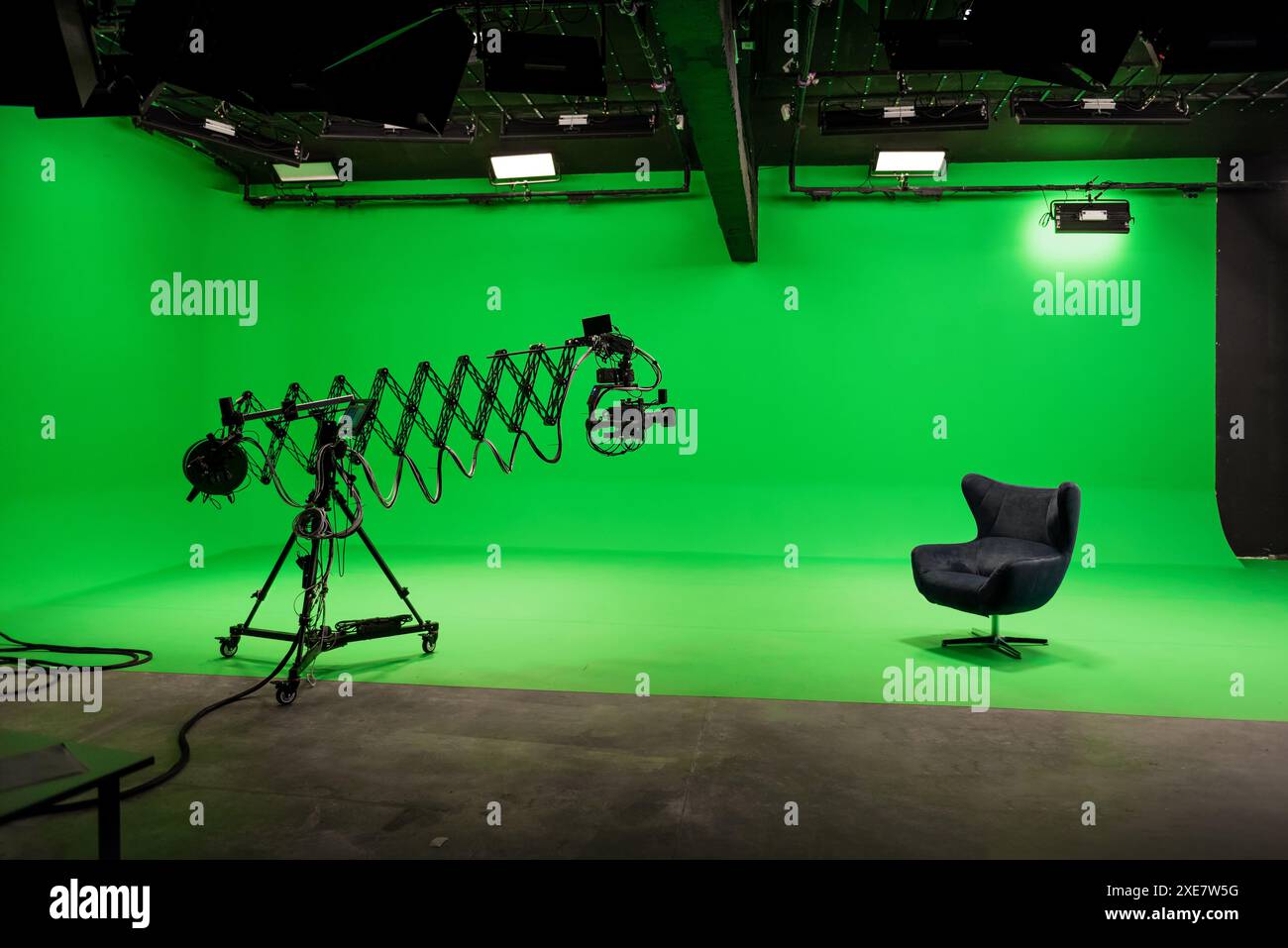 Armchair in TV studio with green background. Dark grey armchair being ...