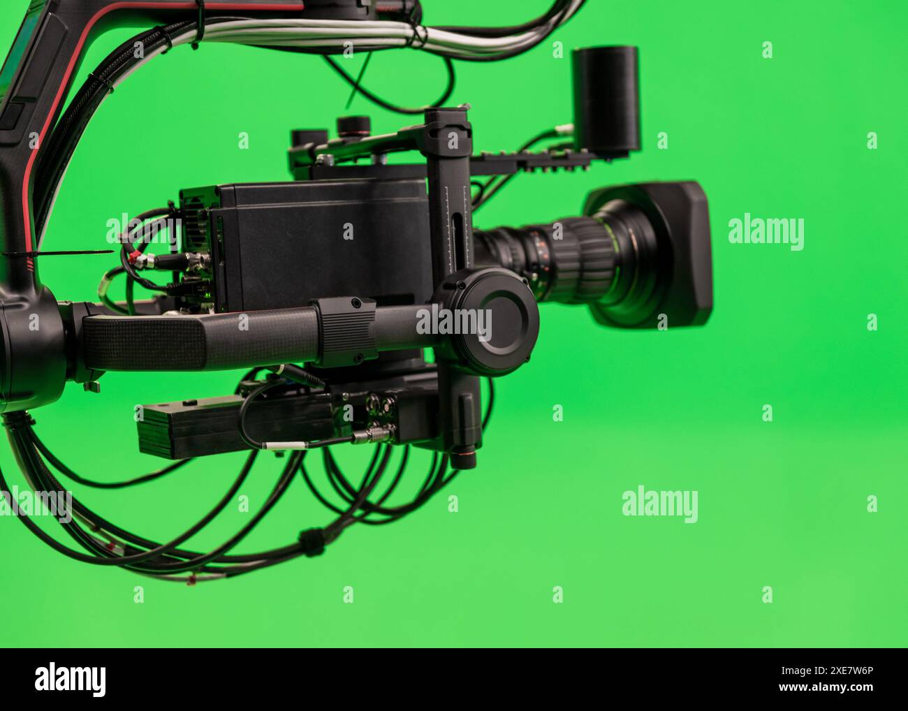 Black camera on carbon jib crane against green background. TV studio ...