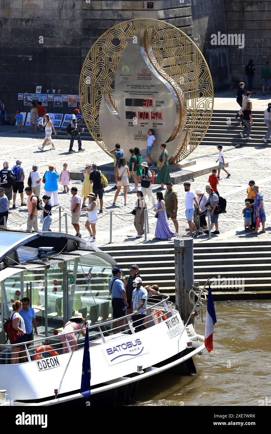 People pose in front of the Countdown Clock for the Paris Olympics ...