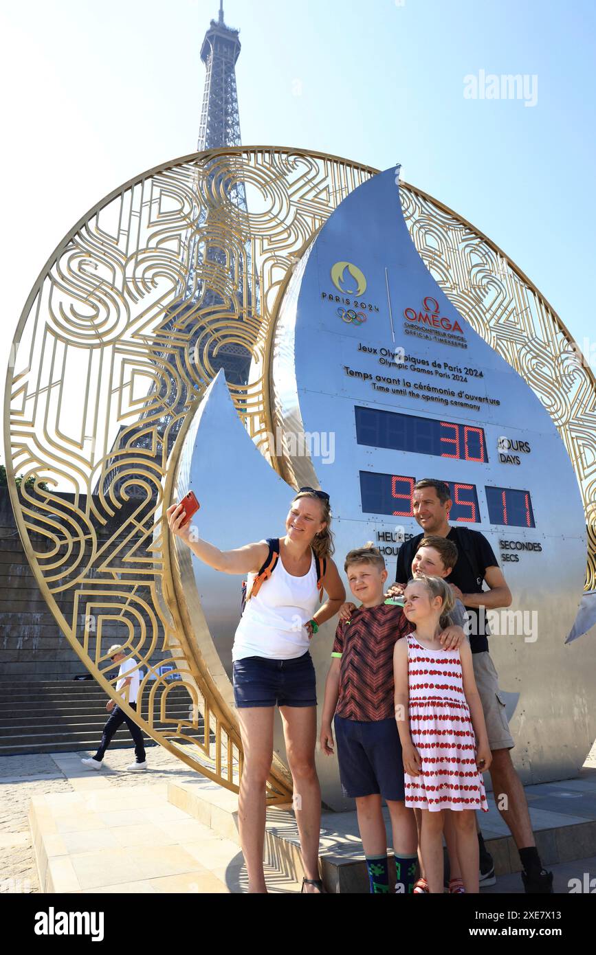 People pose in front of the Countdown Clock for the Paris Olympics ...