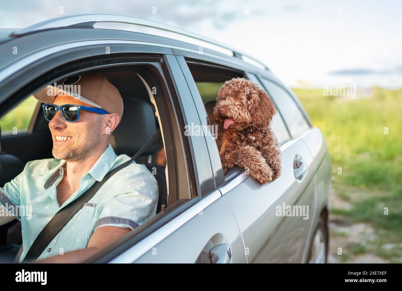 Man in fancy sunglasses enjoys car driving with his happy, fluffy ...