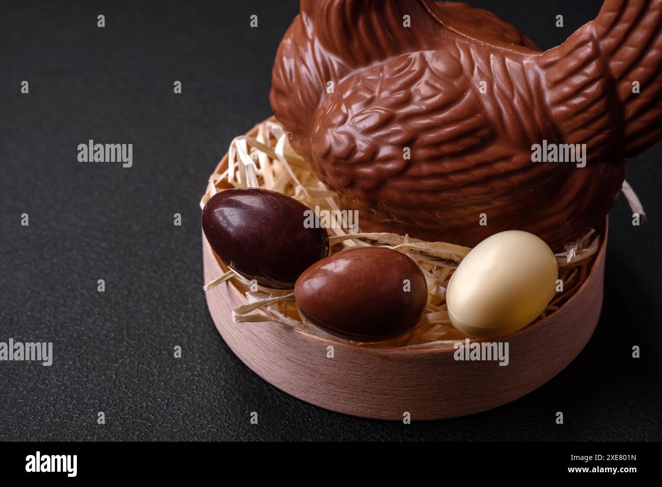 Chocolate Easter hen and eggs in a nest with straw Stock Photo - Alamy