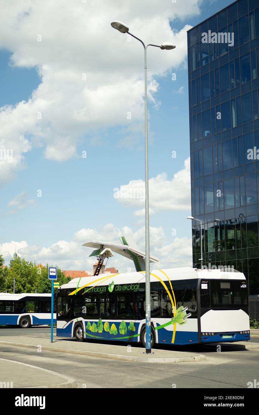 An electric bus stands at an empty bus stop and charges up Stock Photo ...