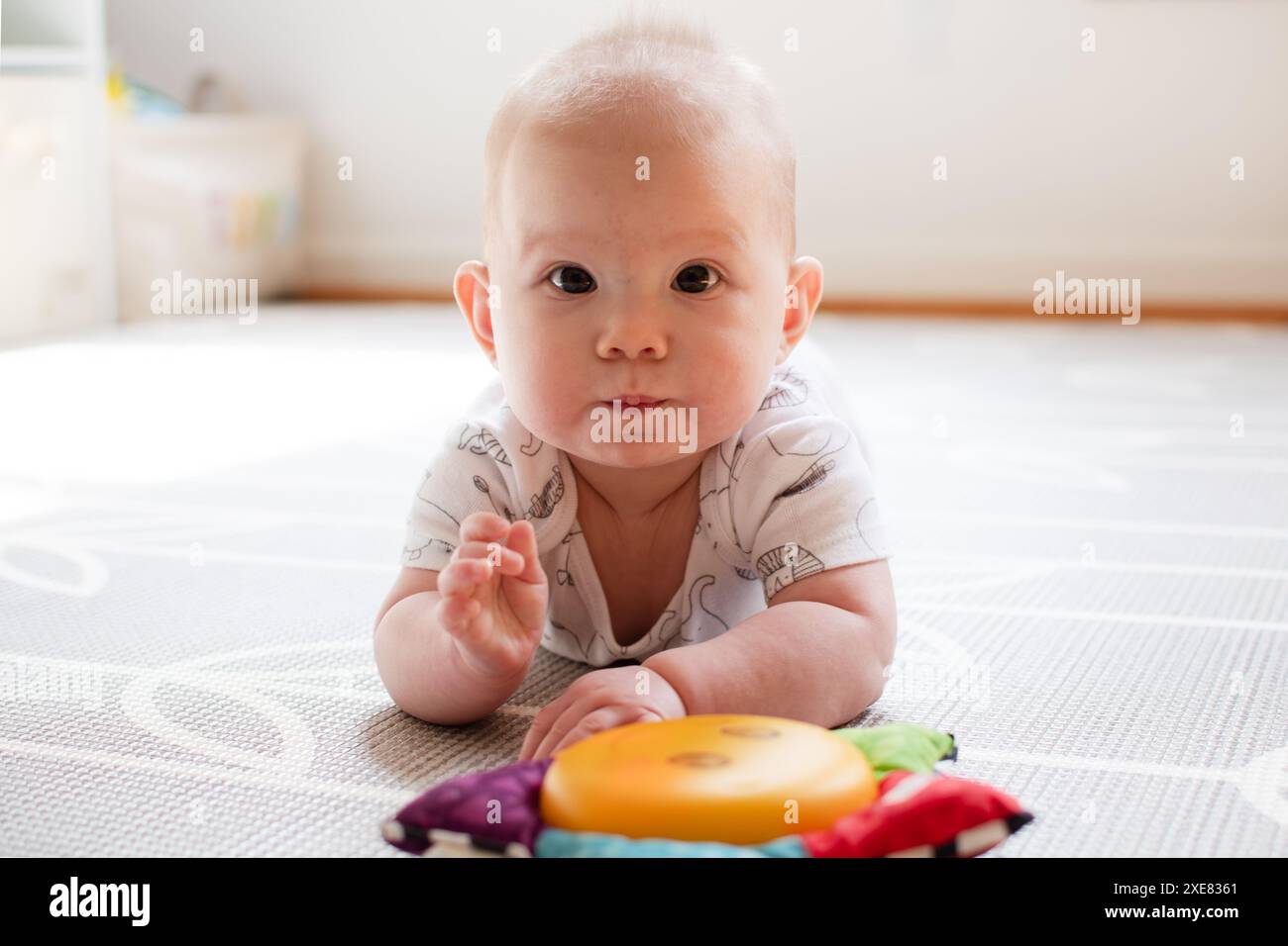 Cute little caucasian baby girl during tummy time on the floor in her ...