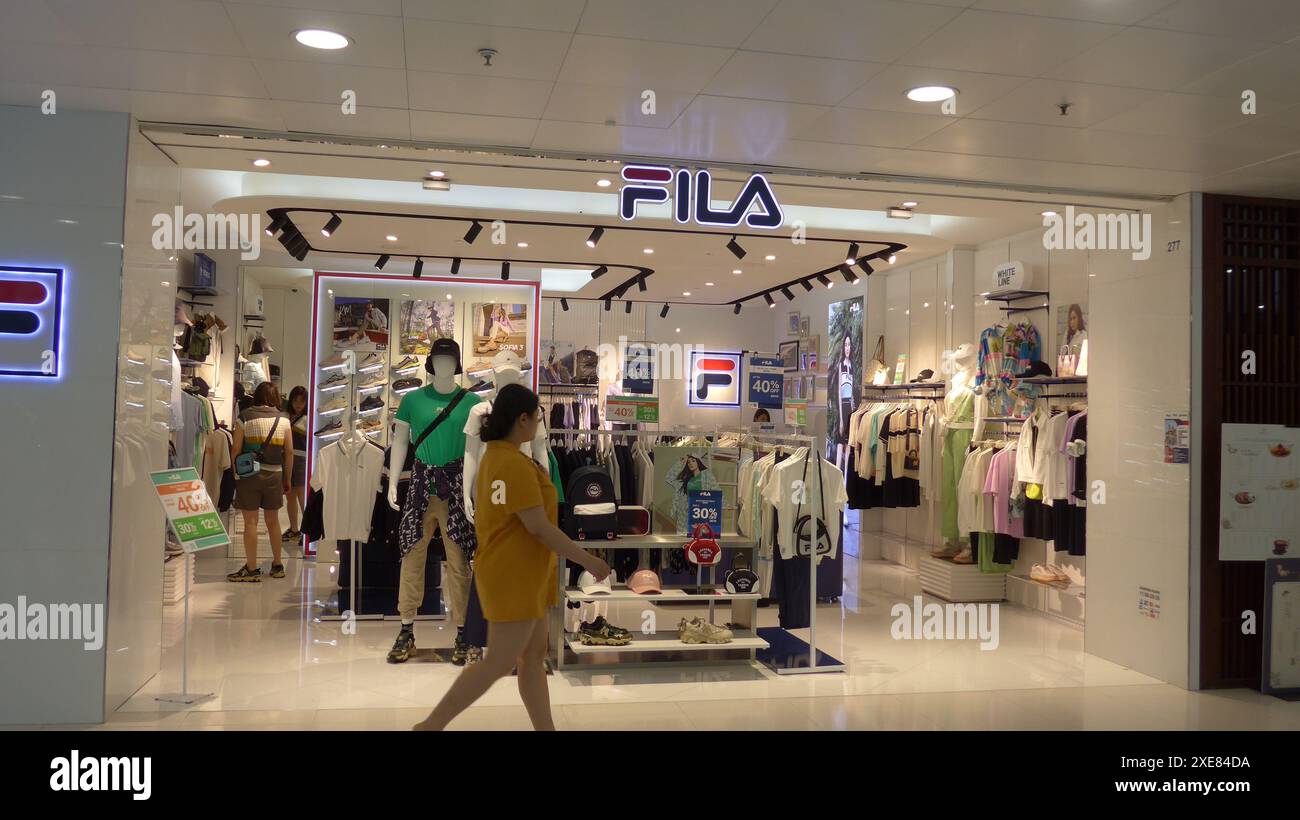 A woman walks past the South Korean-owned athleisure brand Fila logo and store in Hong Kong ...