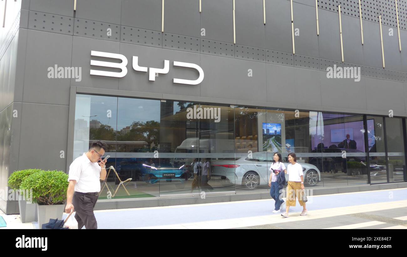 Pedestrians walk past the Chinese multinational manufacturing battery ...