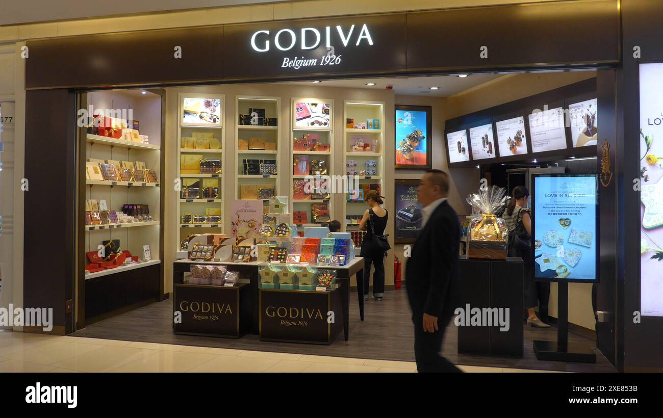 Pedestrians walk past the Belgian-based international chocolate maker Godiva logo and store in ...