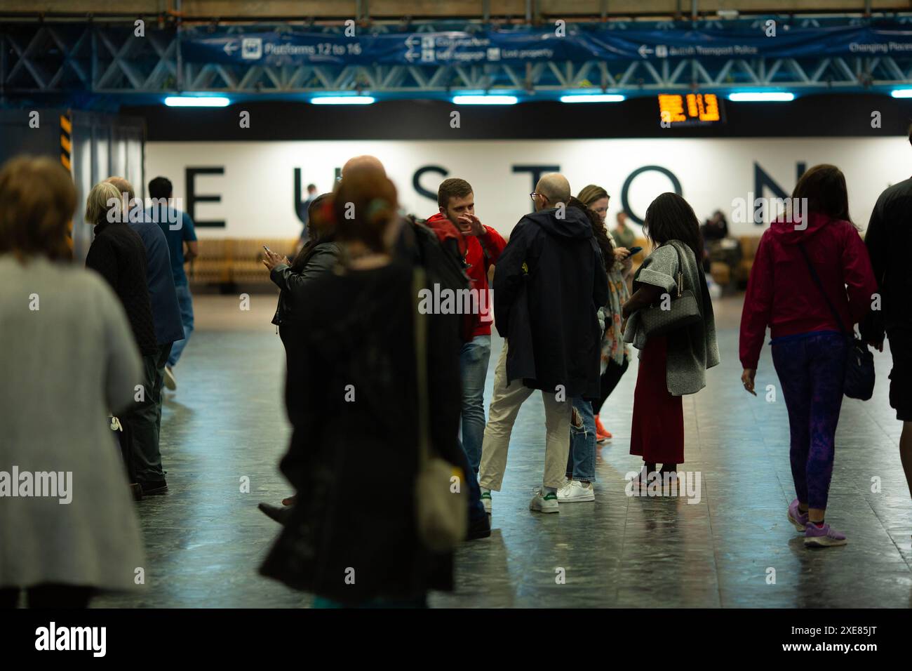 Passengers queue in front of a ticket office at Euston Station in ...