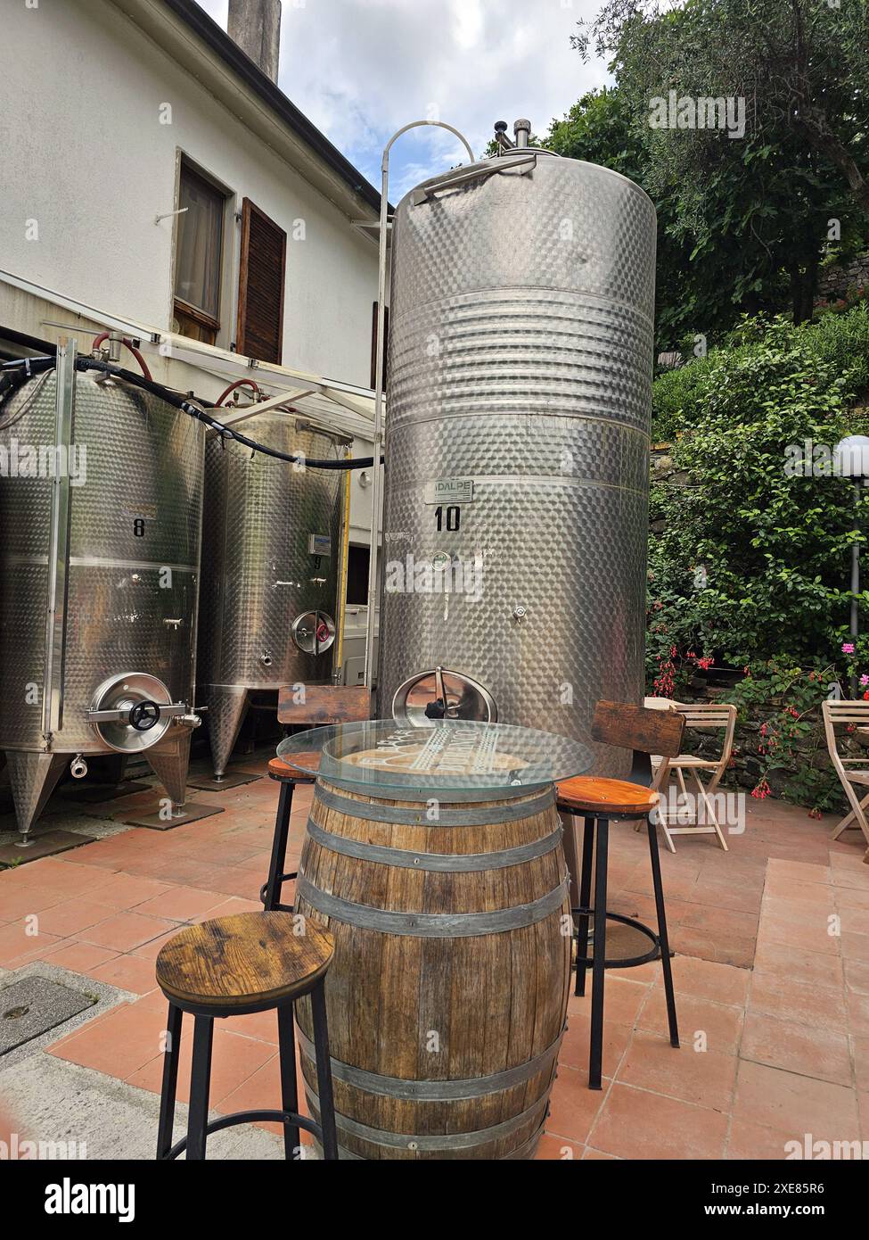 Wine barrel table and bar stools in front of large metal wine barrels ...
