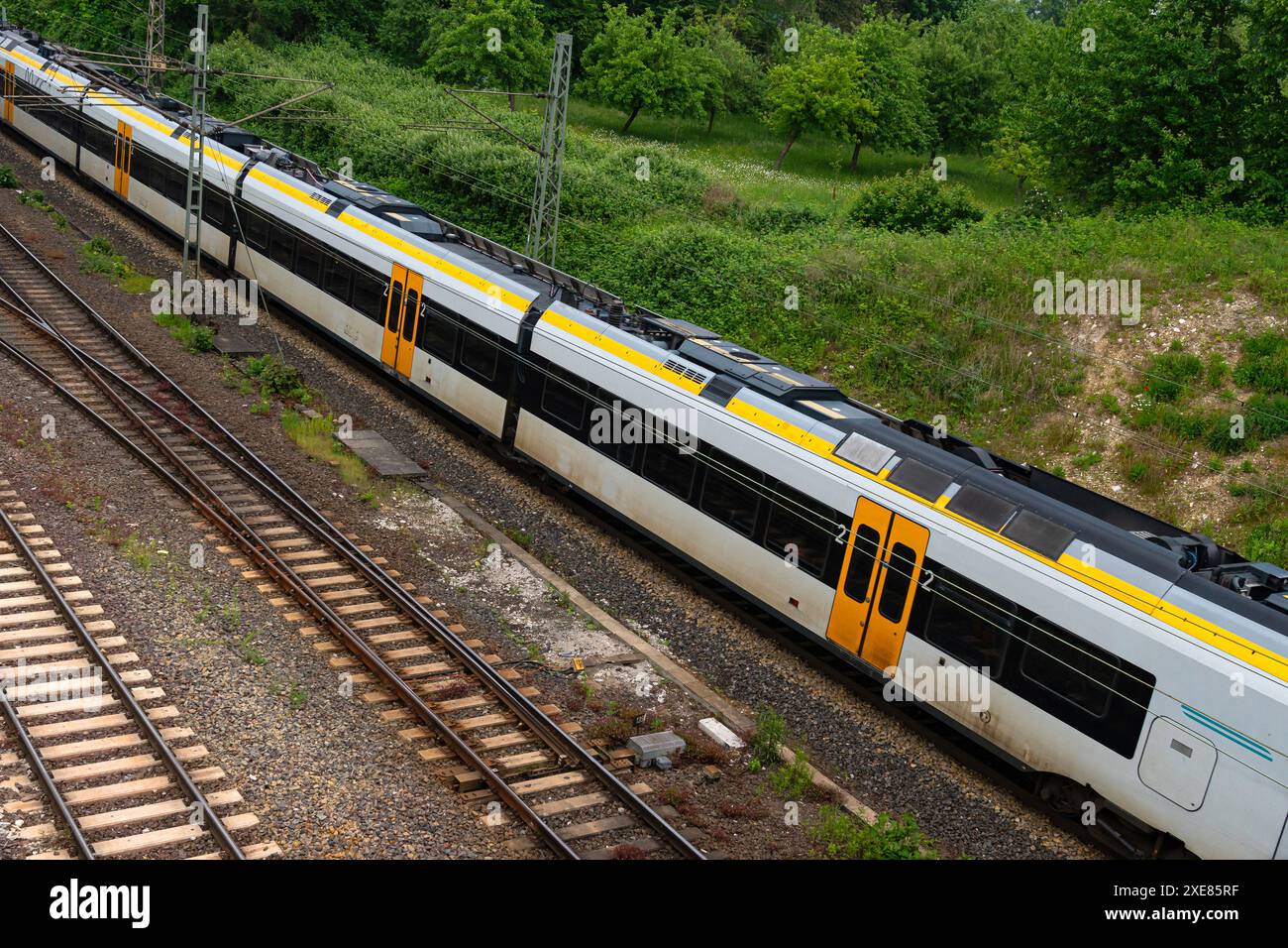 Top view of a high-speed passenger train rushing through a forest area ...