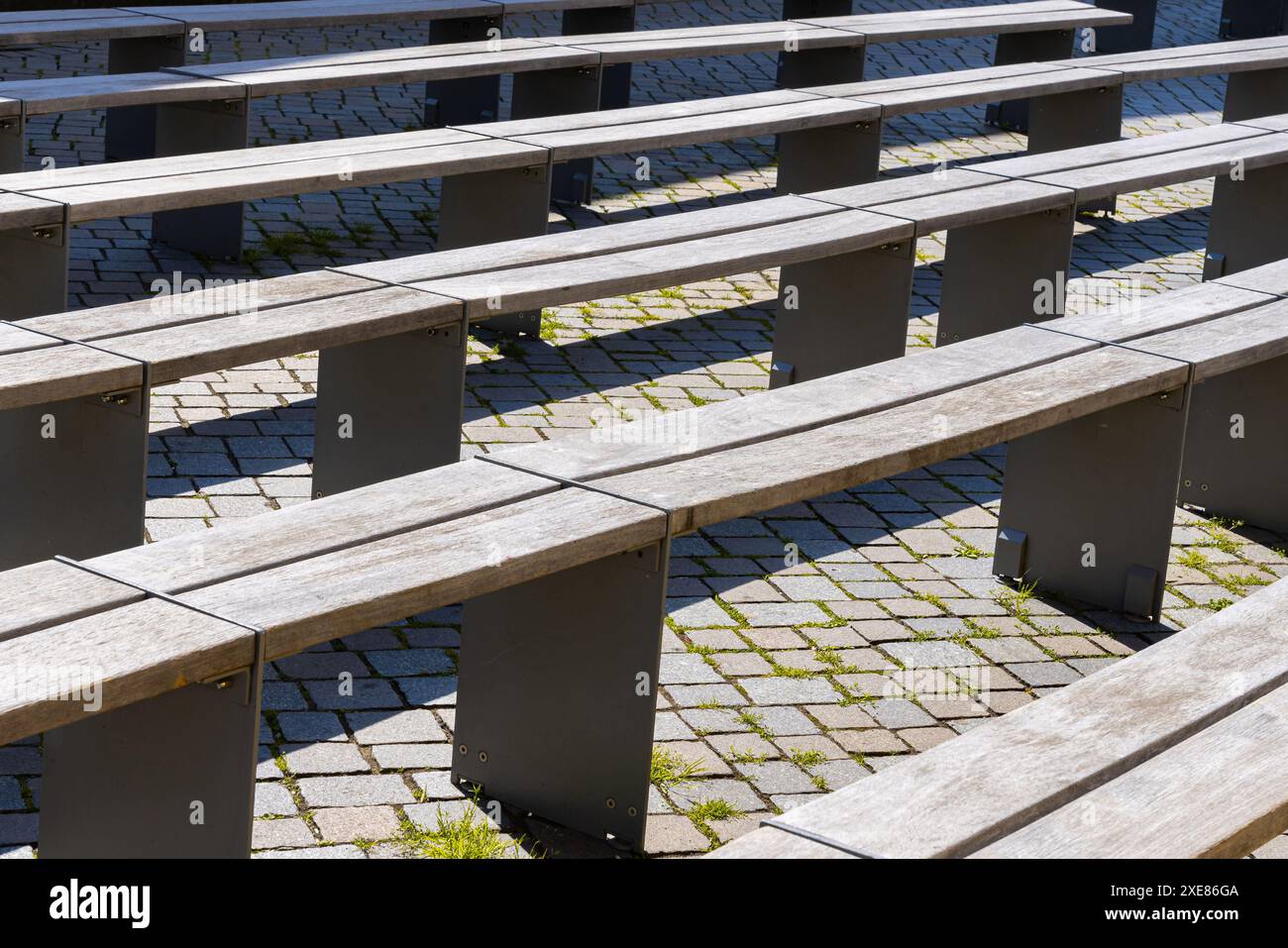 Long wooden benches of the summer theater located diagonally. View from ...