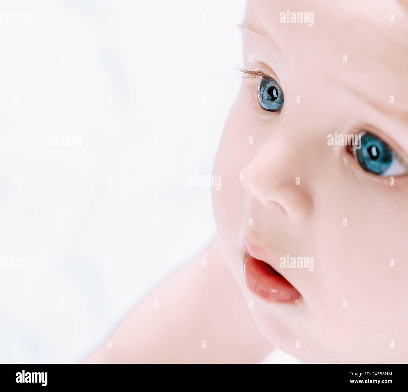 Close up portrait of an adorable baby with big blue eyes and delicate ...