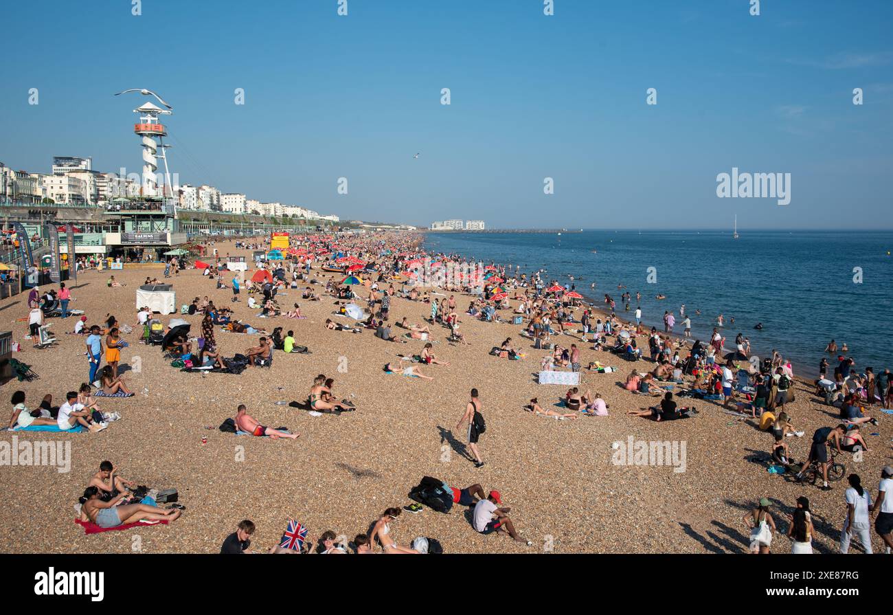 Crowd of British people sunbathing swimming and relaxing in the beach ...