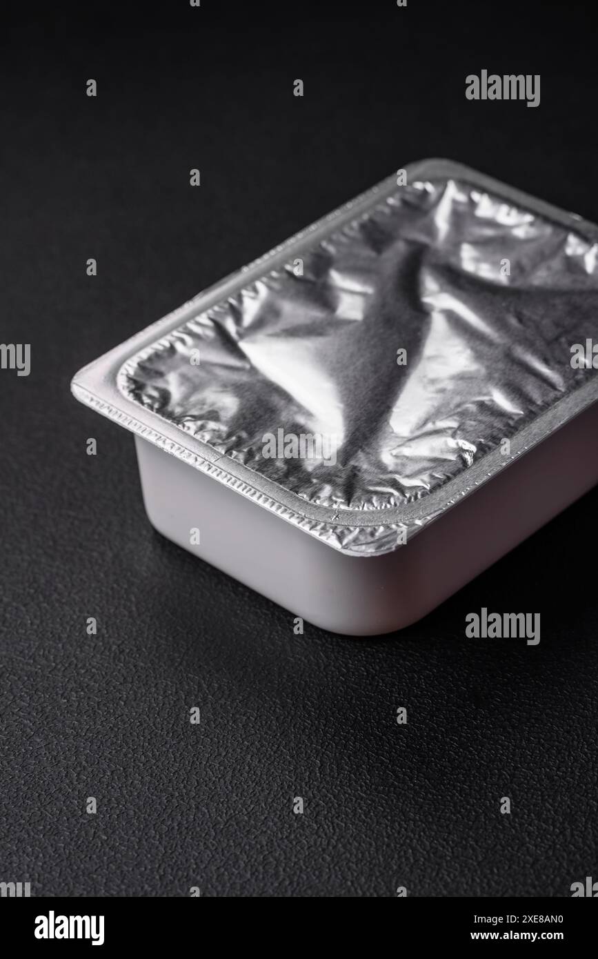 Rectangular plastic box with yogurt or cheese hermetically sealed with ...