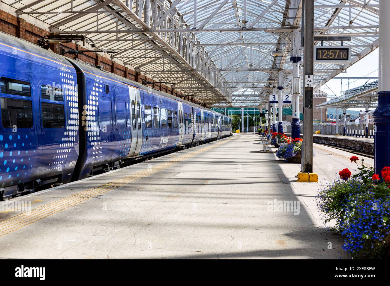 Electric blue Scot Rail train and coaches waiting at an empty platform ...