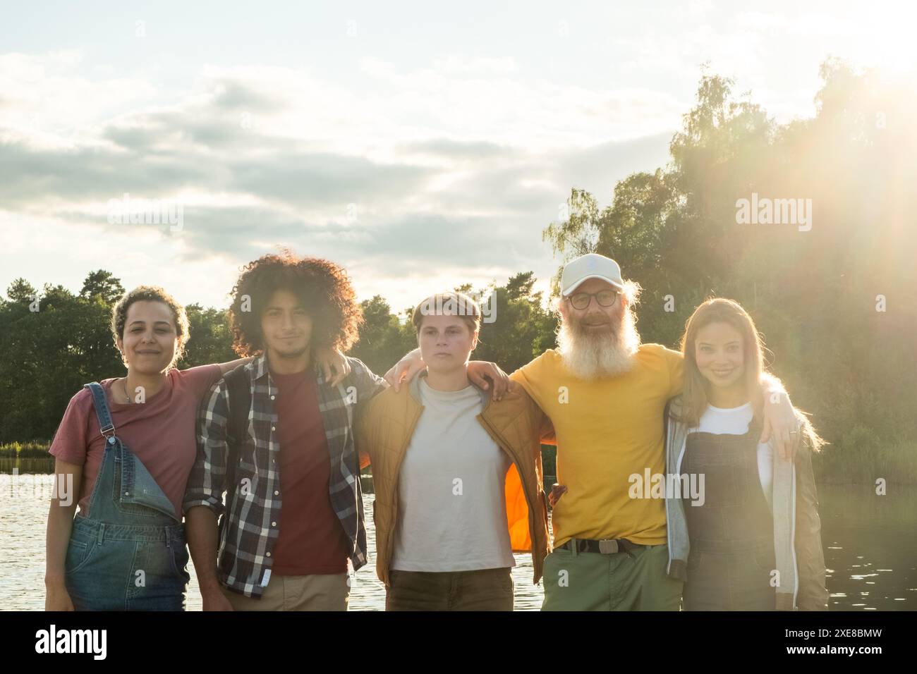 Diverse Friends Bonding at Lakeside During Sunset Stock Photo - Alamy