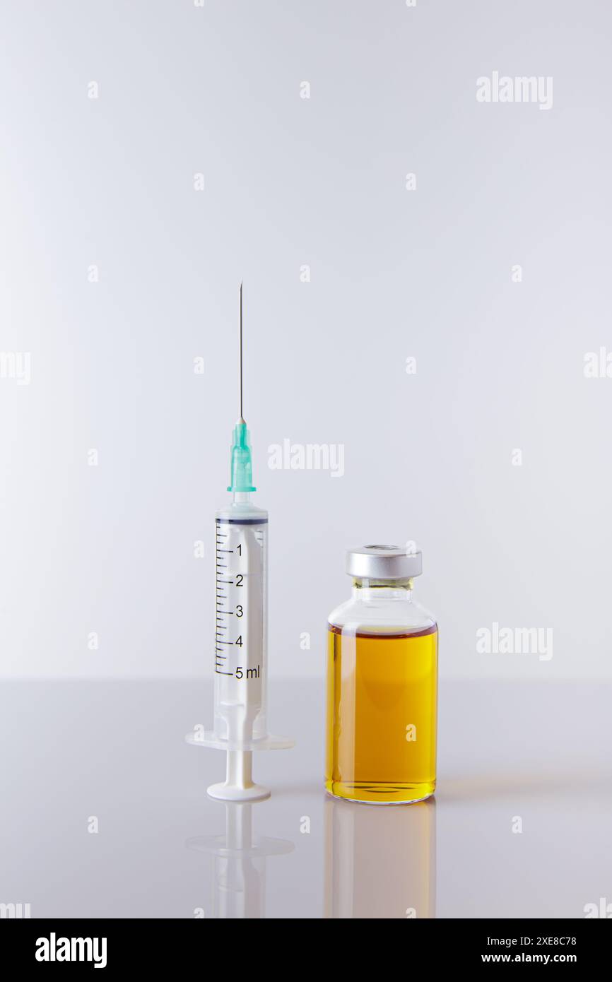 Syringe with its needle and injectable medicine bottle in upright ...