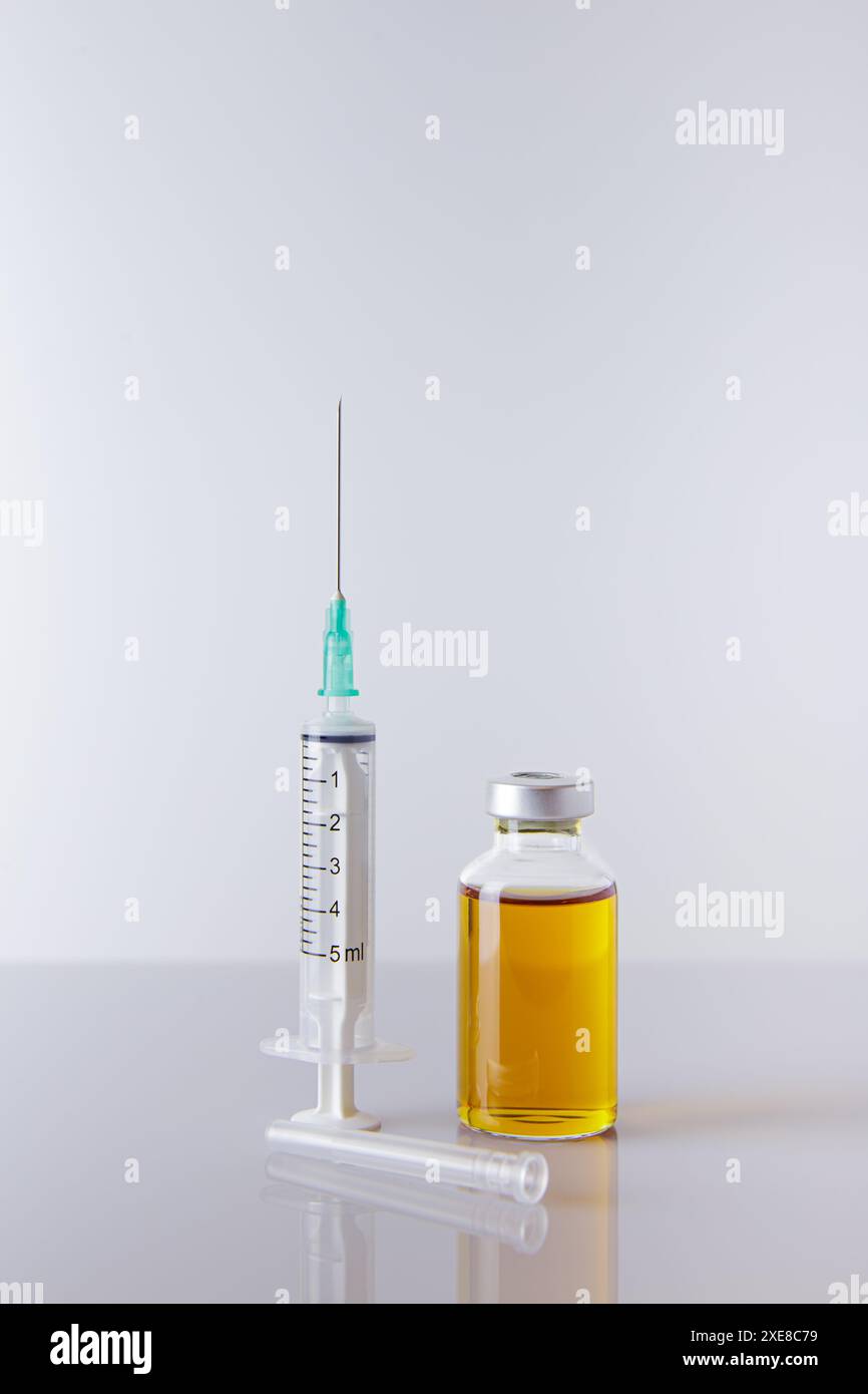 Syringe with its needle and injectable medicine bottle in upright ...
