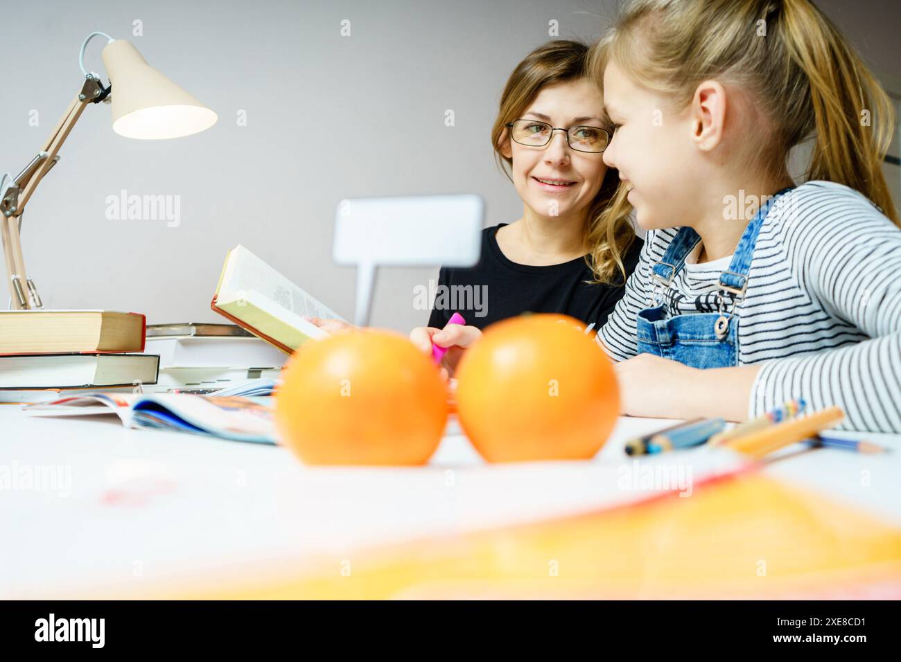 Mother and daughter doing homework together, styding and learning ...