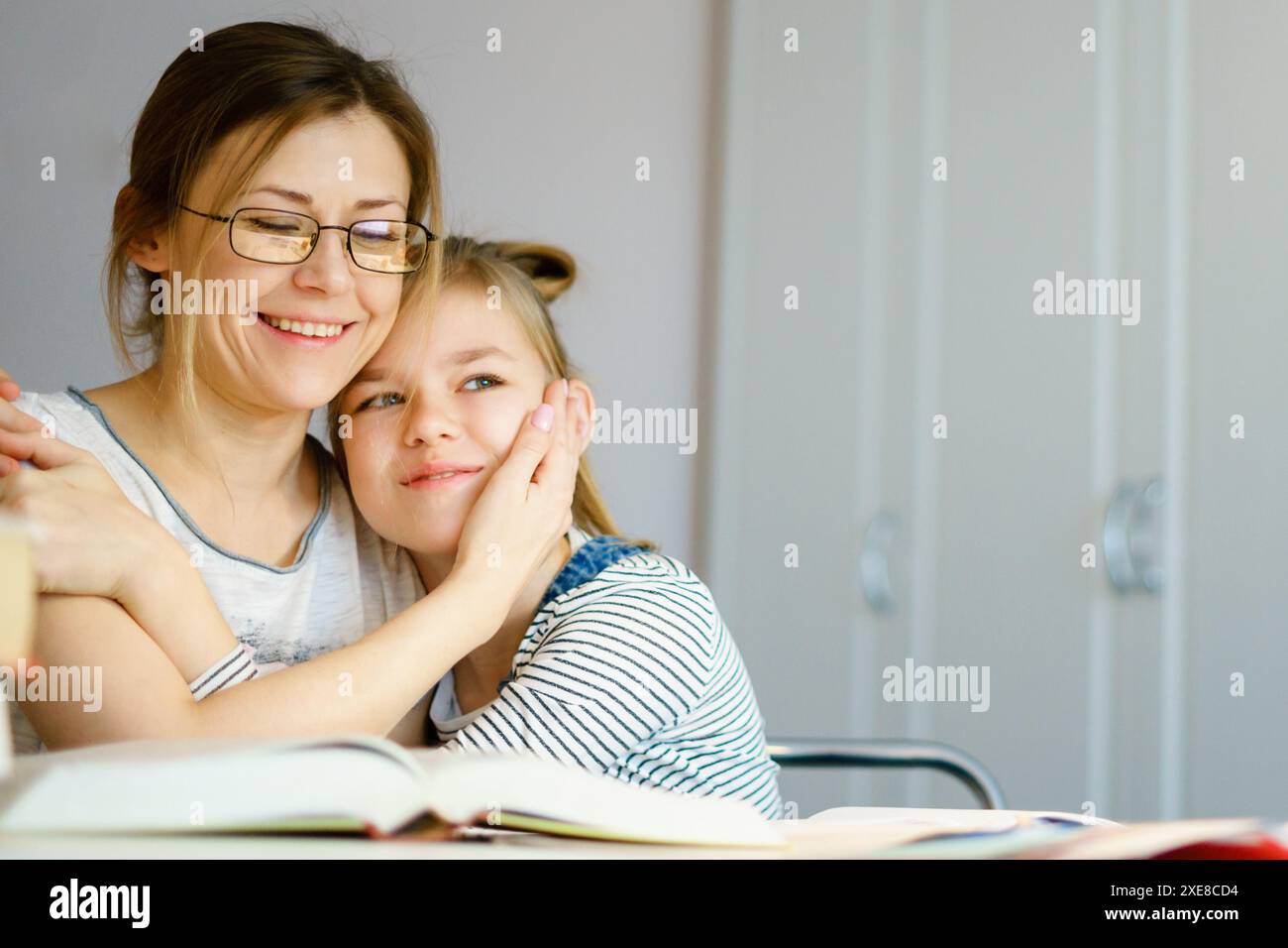 Mother and daughter doing homework together, styding and learning concept, doing tasks for ...