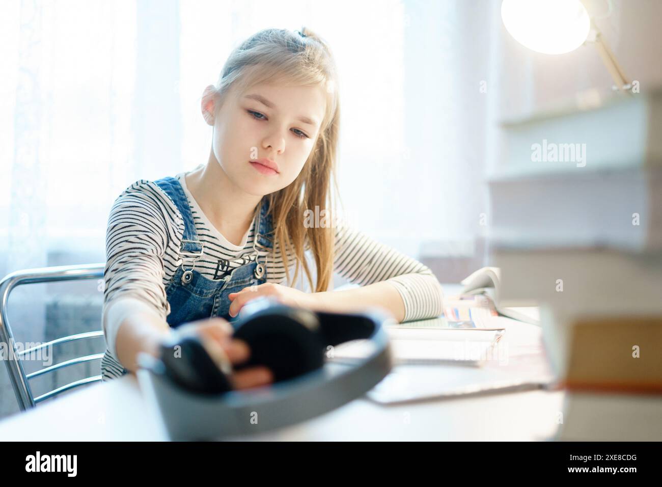 Teenage girl doing homework at table at home preparing for school test ...