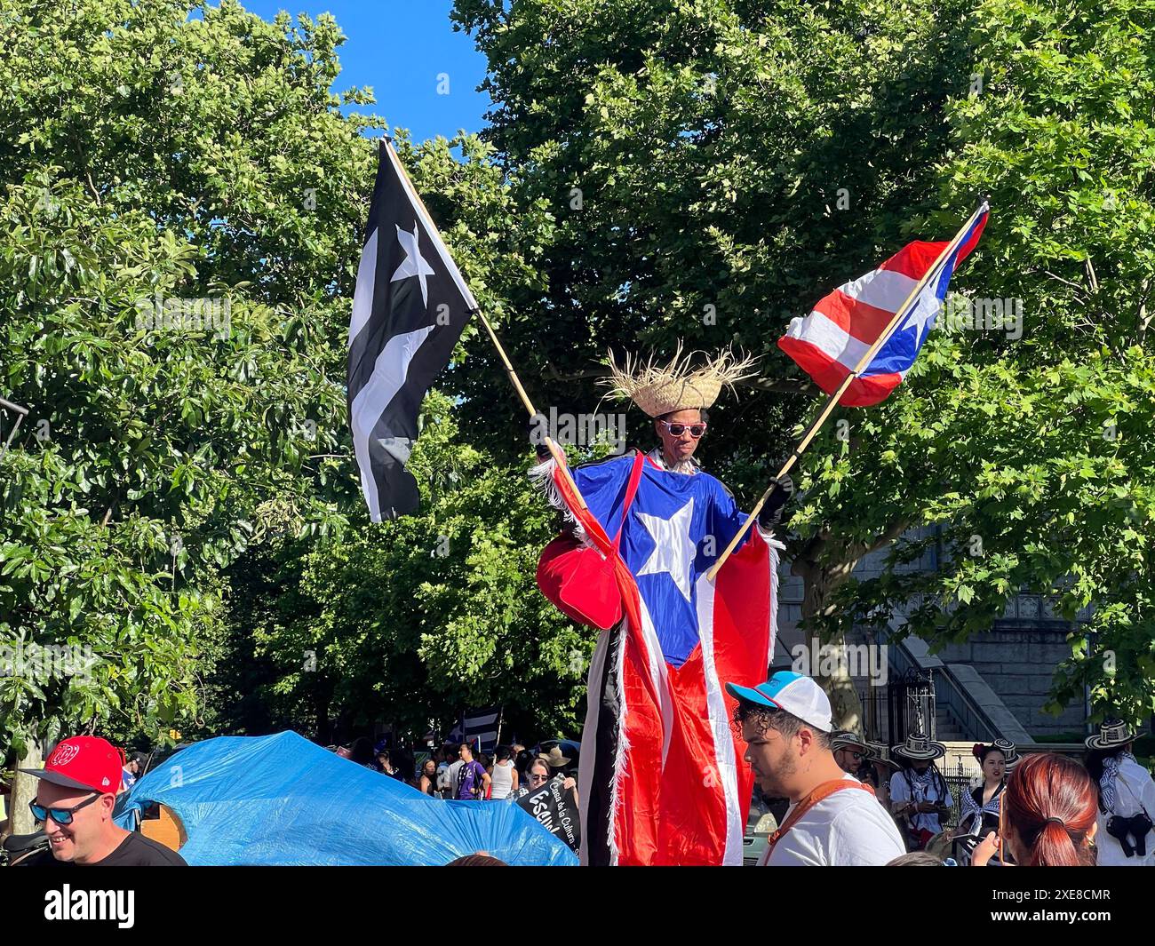 Stilt walker carries the now well know black and white Puerto Rican ...