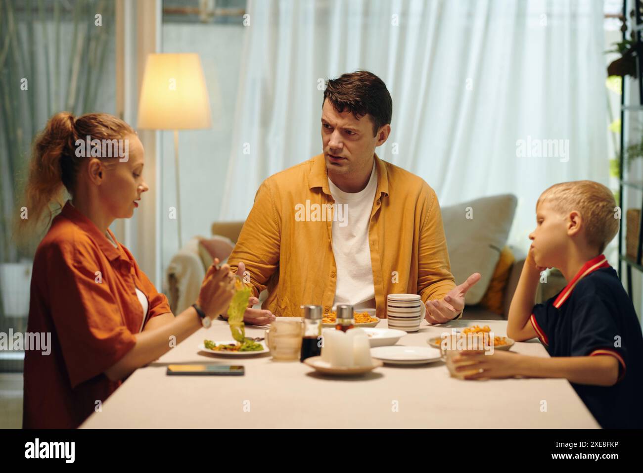 Family having an argument while having dinner with their son at home ...