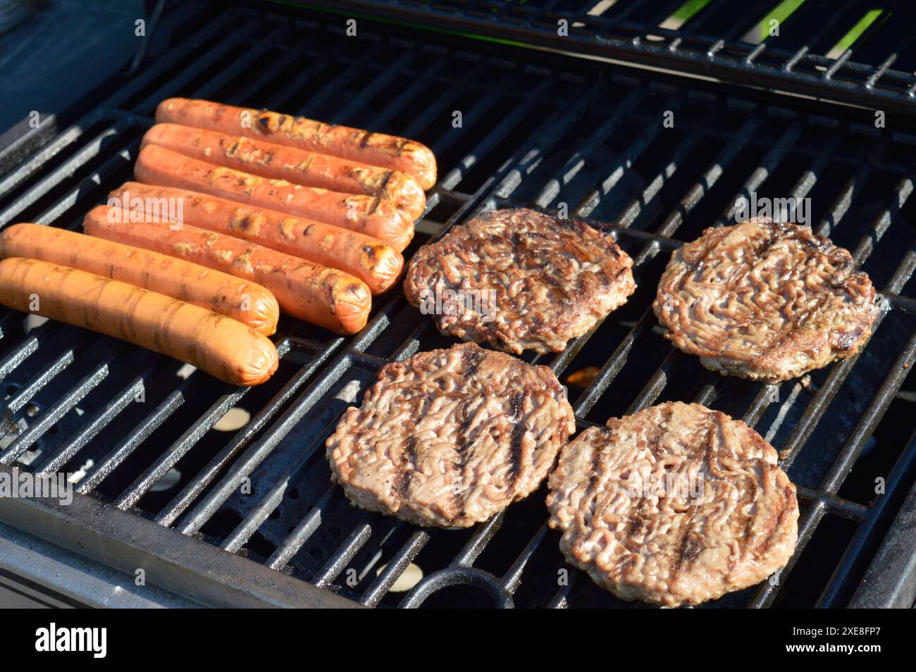 Burgers and hot dogs cooking on the open flame BBQ Stock Photo - Alamy