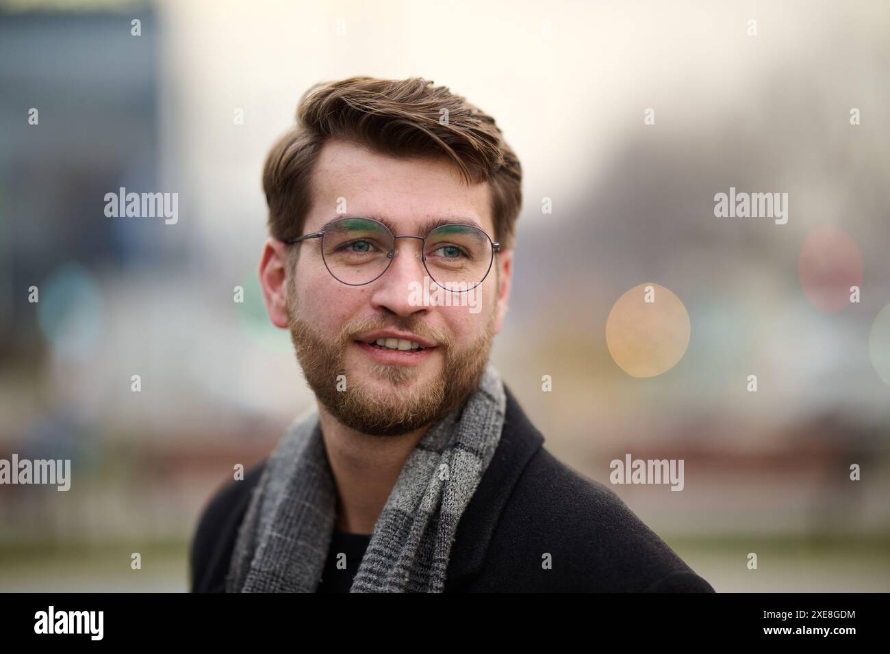 A handsome young man, dressed in a stylish suit, tie, and glasses ...
