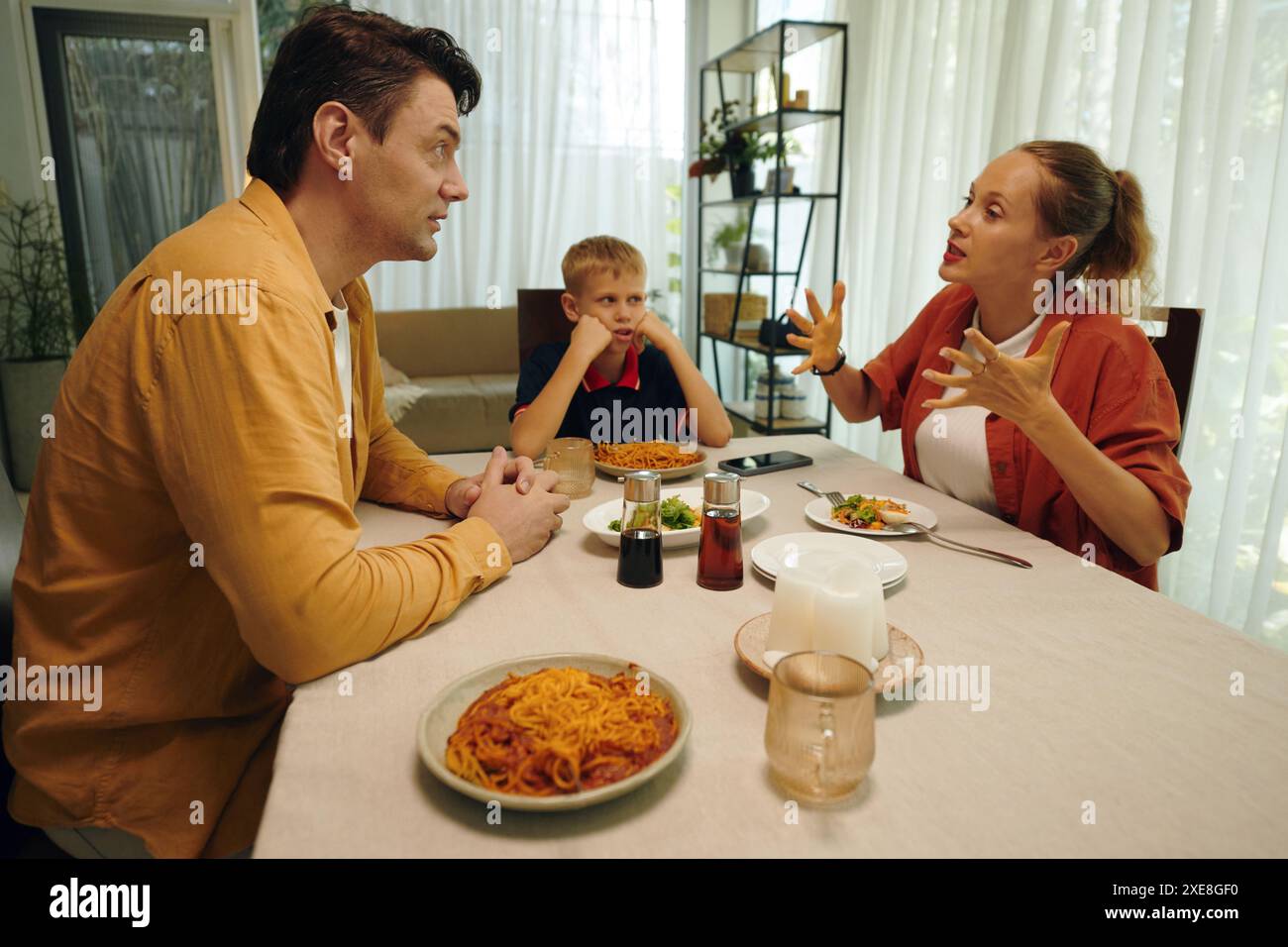 Family arguing during dinner with their son watching for their quarrel ...