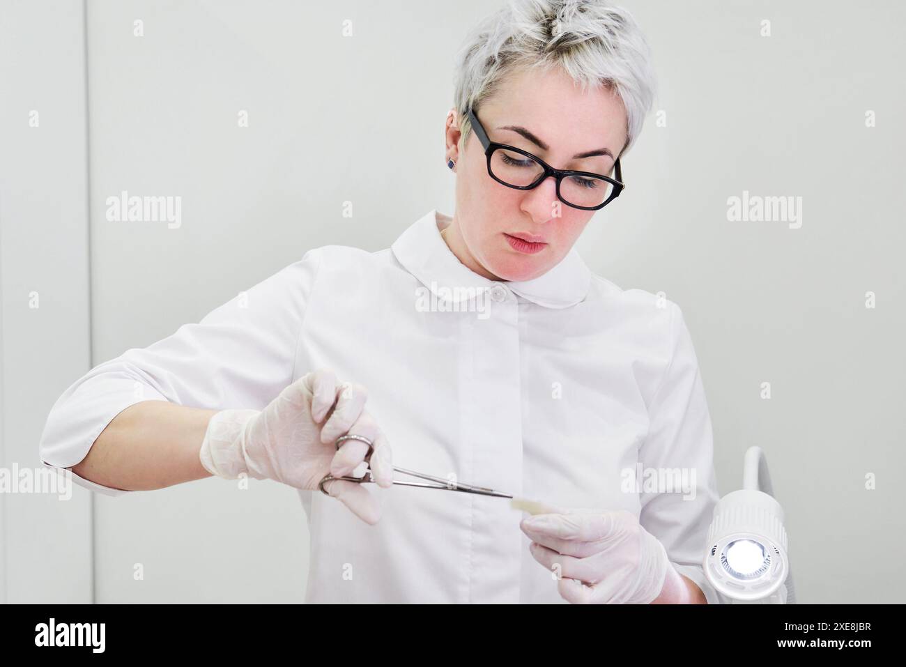 Doctor wearing gloves using a surgical forceps to open band aid Stock ...