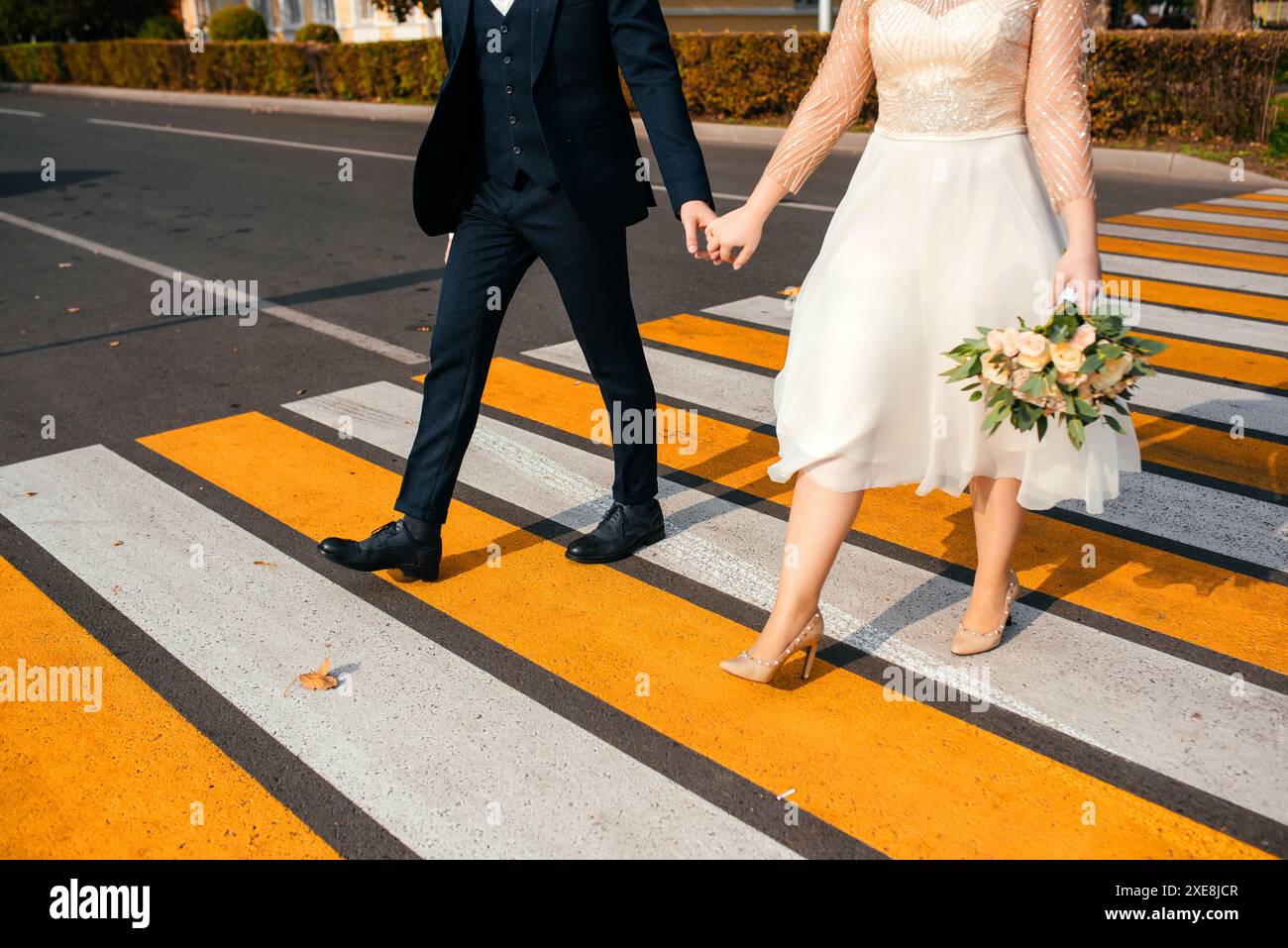 Caucasian couple holding hands crossing city intersection Stock Photo ...