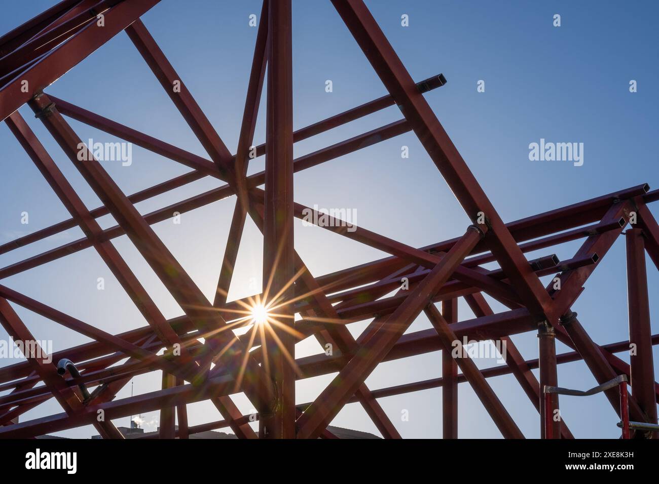 Geometric composition of red metal beams and a blue crane in a modern ...