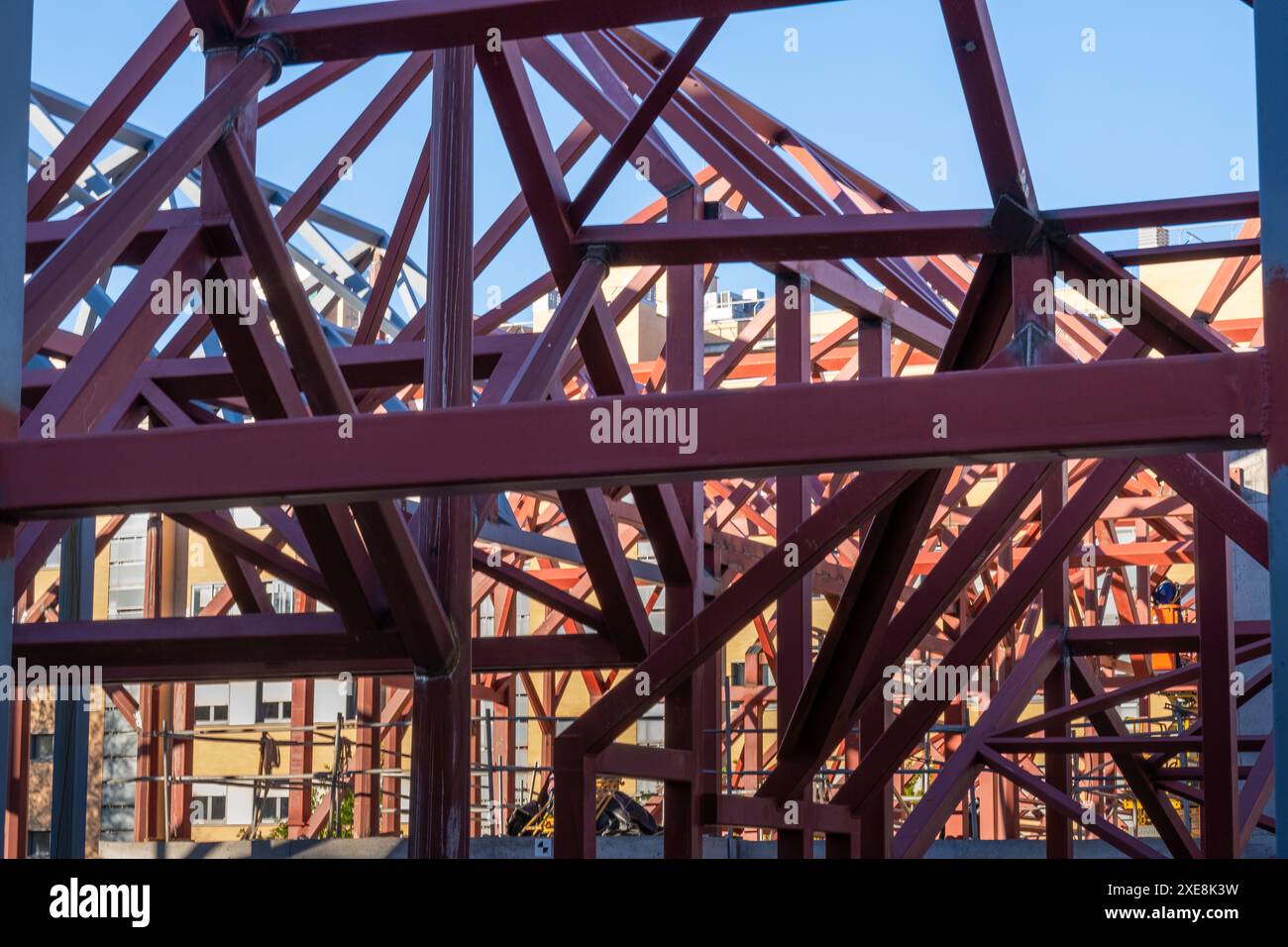 Geometric composition of red metal beams and a blue crane in a modern ...
