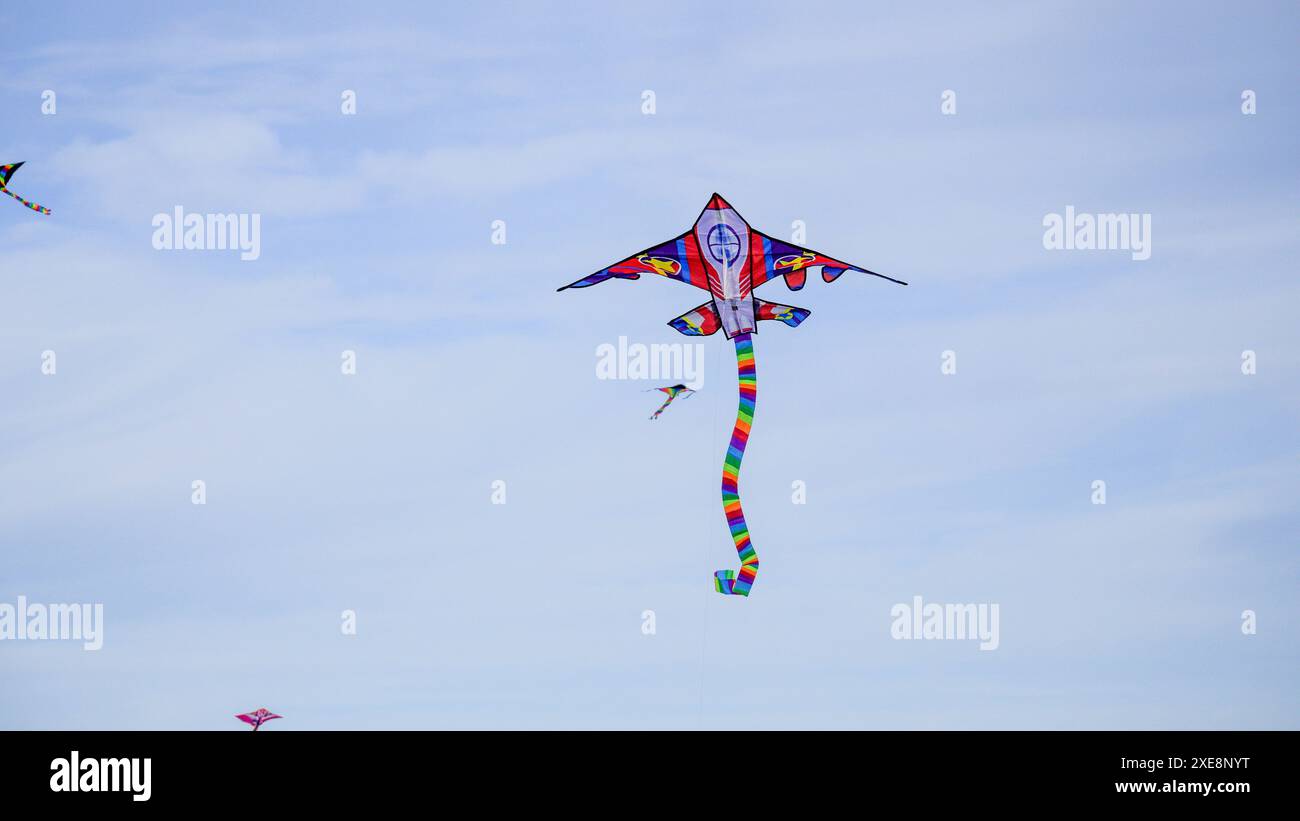 Rocket shaped kite, soaring through the blue sky with white clouds in ...