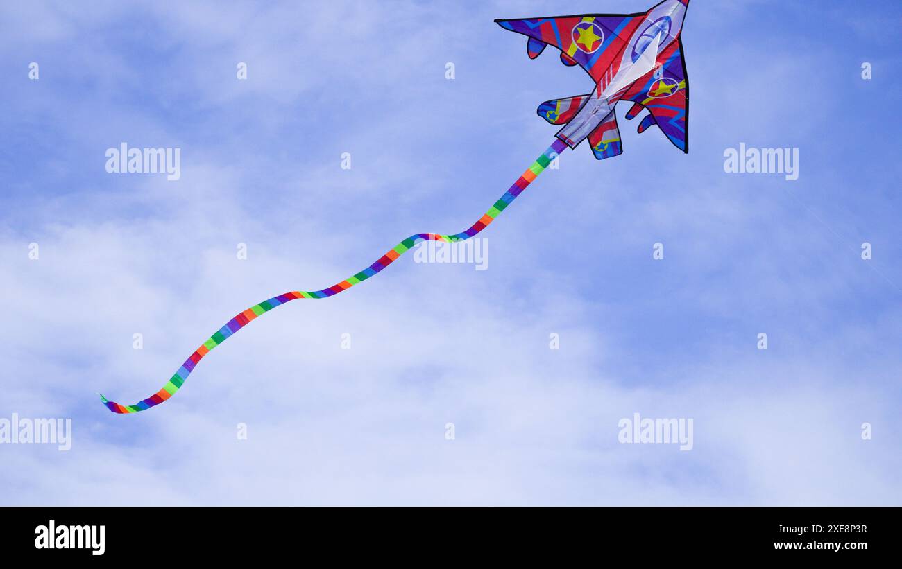 Rocket shaped kite, soaring through the blue sky with white clouds in ...