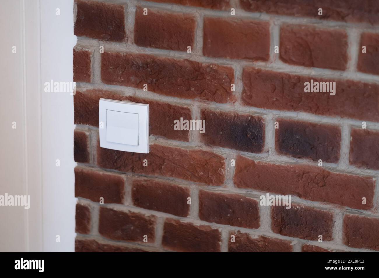 Detail of a white light switch on the aged red brick wall. ecology and ...