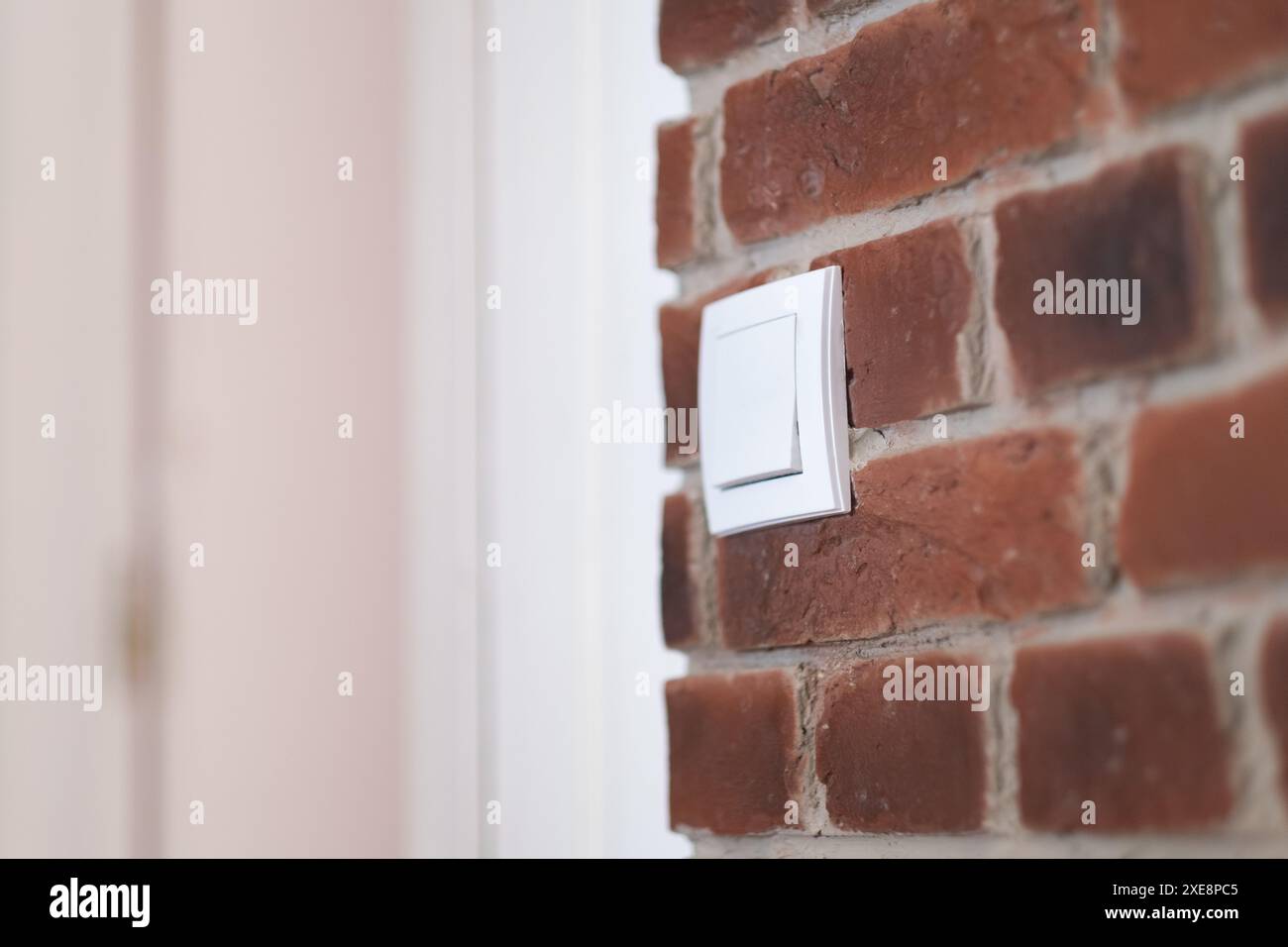Detail of a white light switch on the aged red brick wall. ecology and ...